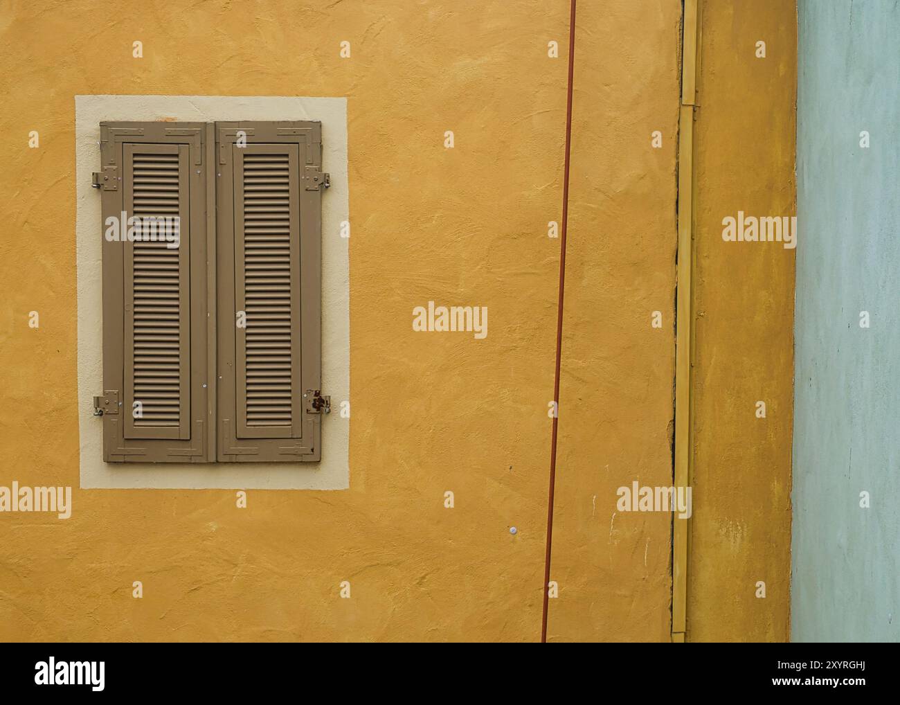 Ochre-colored house wall with wooden window embodies Mediterranean ...