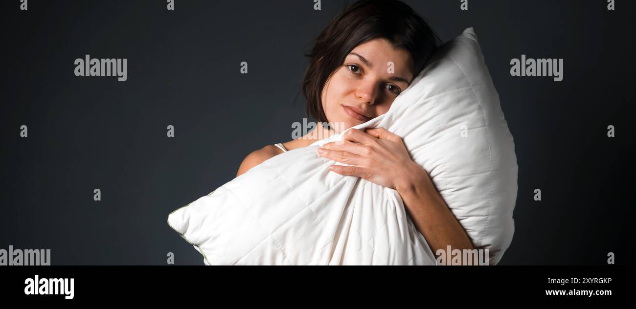 Girl hugs a white soft pillow and wants to sleep Stock Photo - Alamy