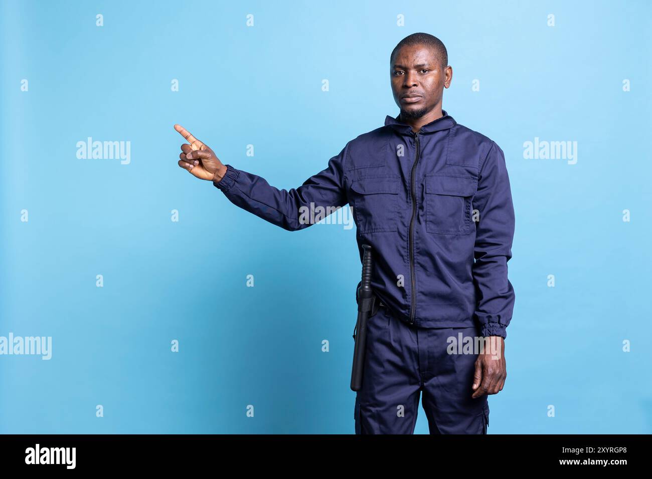 African american serious security agent in uniform pointing to the left ...