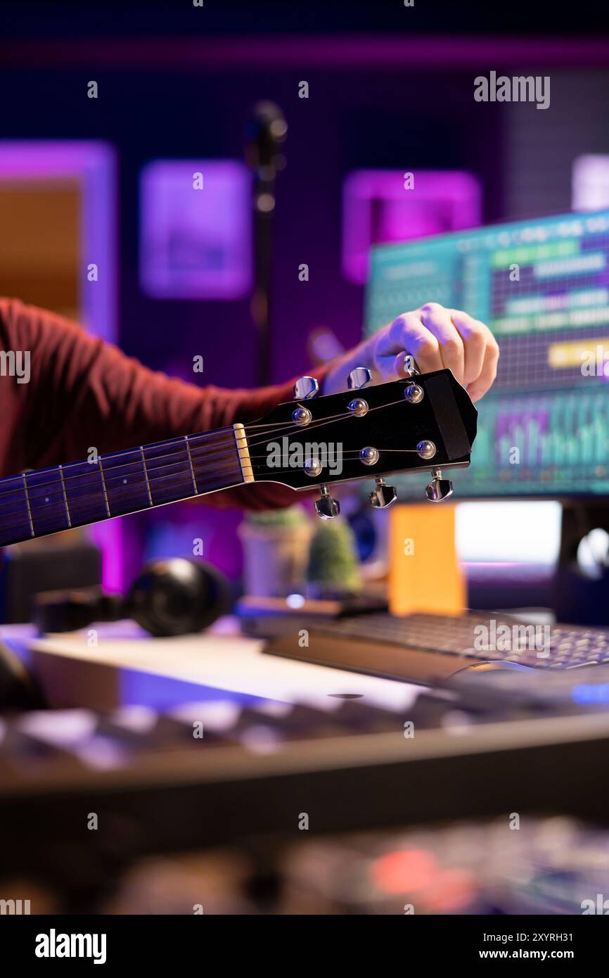 Producer tuning his acoustic instrument to record new sounds, working ...