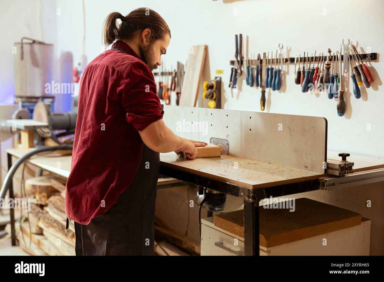 Skilled carpenter meticulously operating wood shaper in assembly shop ...