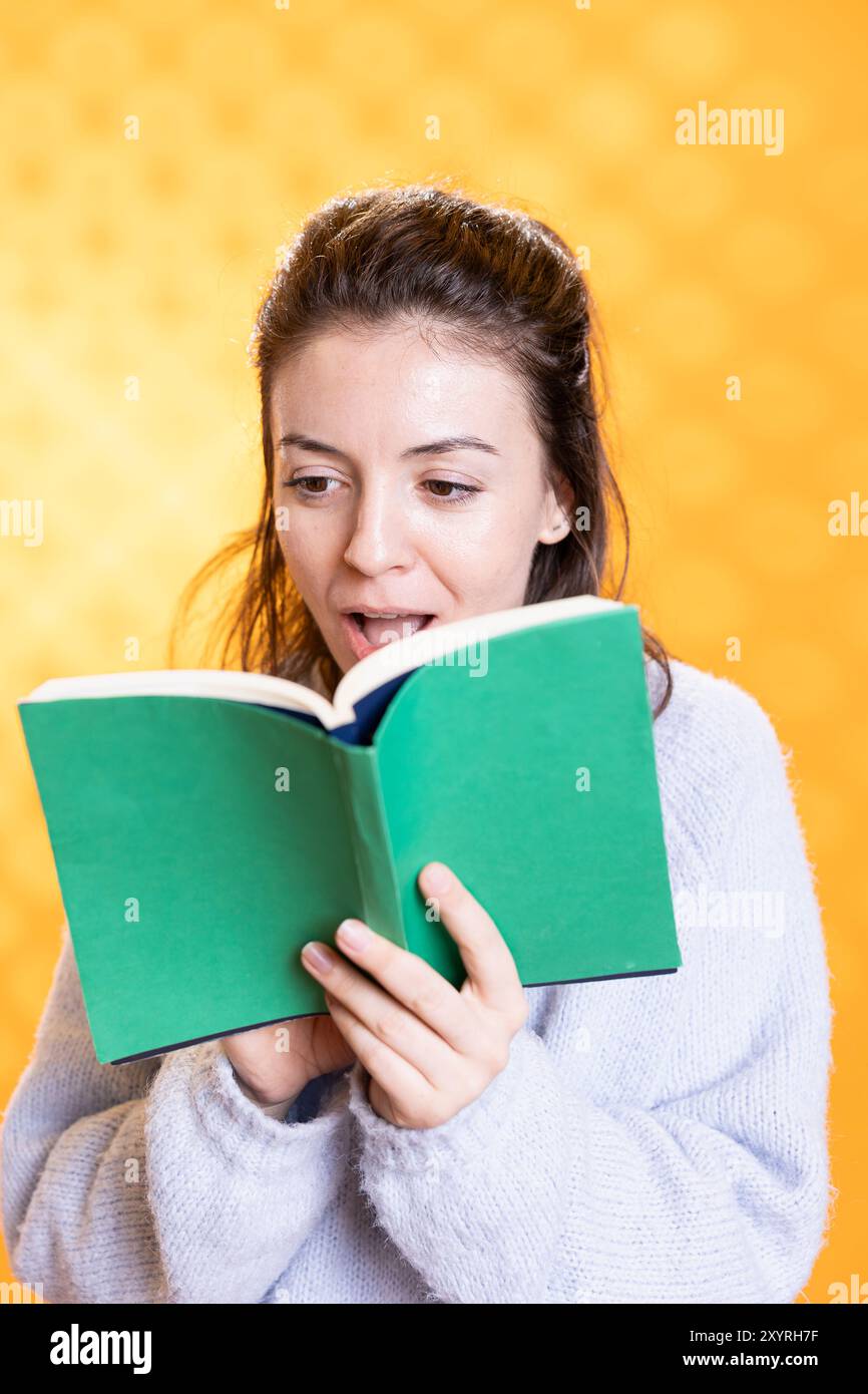 Woman gasping while reading intriguing book, feeling surprised ...
