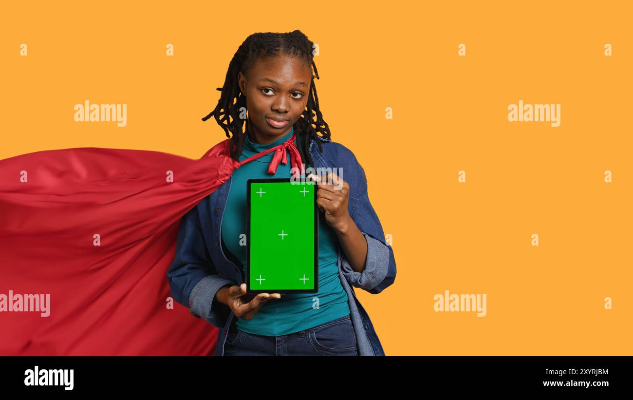 Portrait of joyful woman portraying superhero showcasing green screen ...