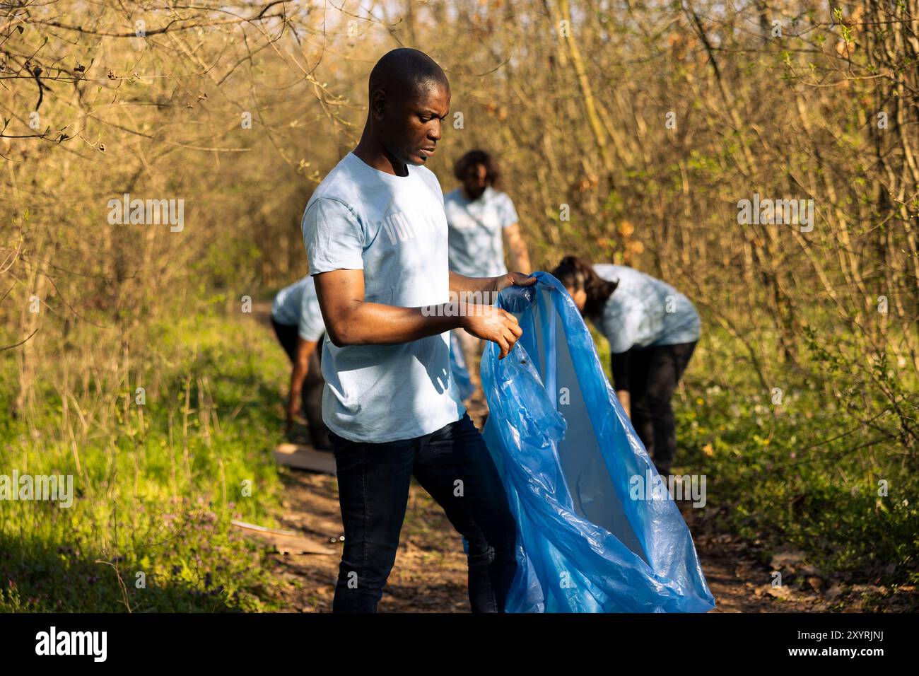 African american person collecting garbage in a bag for community ...