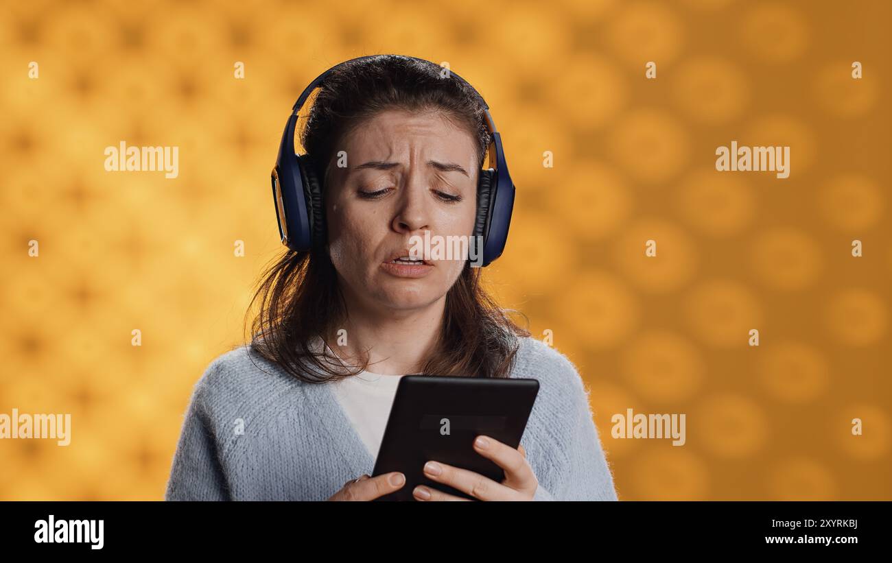 Voice actor frowns while reading ebook, portraying character, studio ...