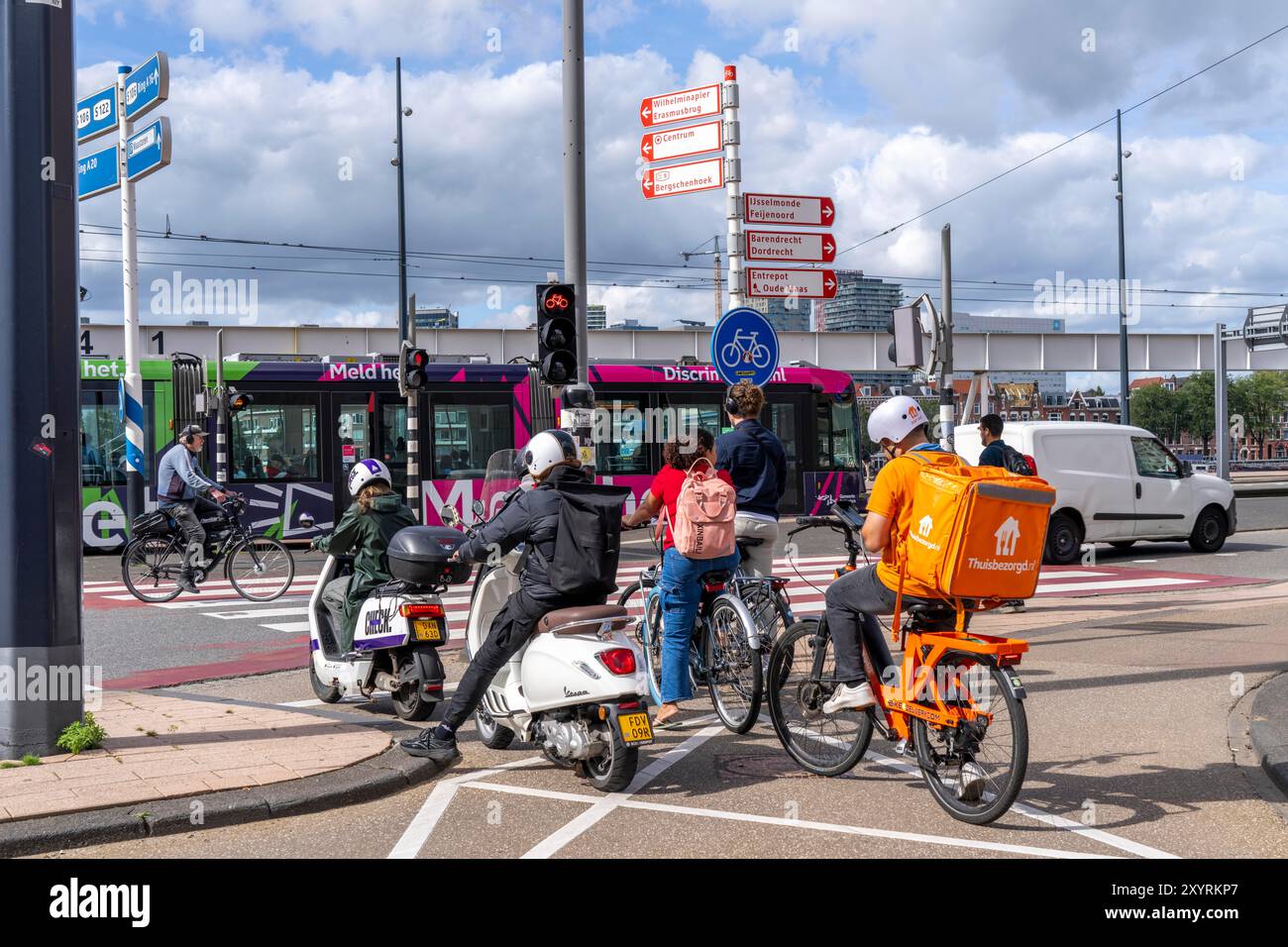 Cyclists, moped riders, waiting at a red cycle path traffic light ...
