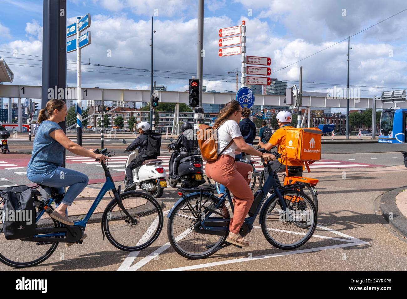 Cyclists, moped riders, waiting at a red cycle path traffic light ...