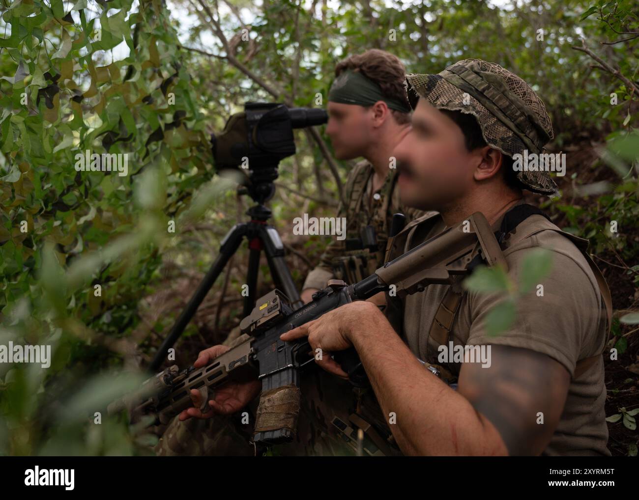U.S. Army Green Berets identify and observe simulated targets from a ...
