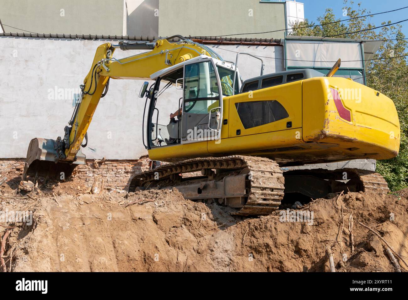 Process of demolition of old building dismantling. Excavator breaking ...