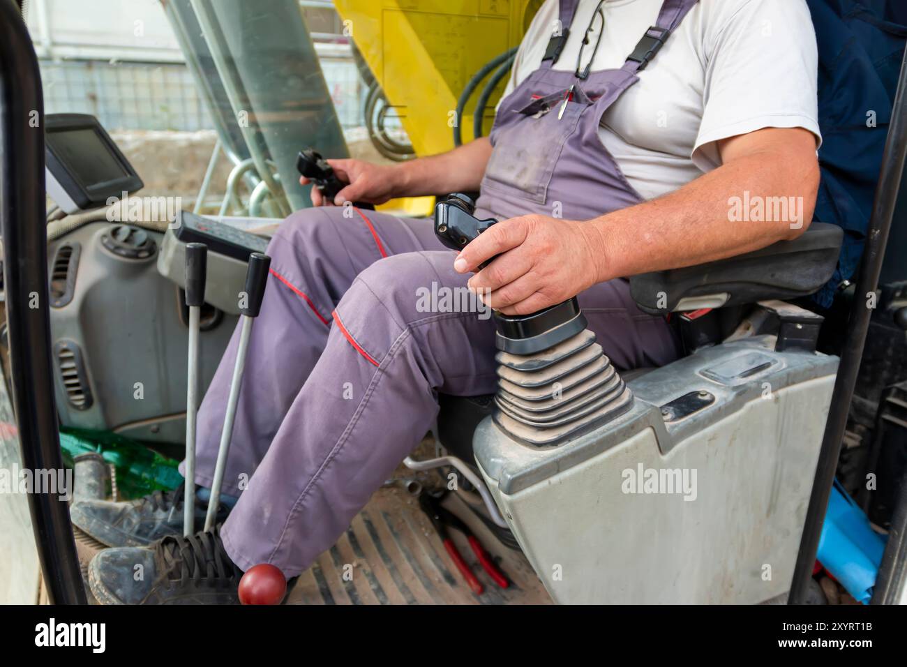Mature man worker operating excavator on construction site Stock Photo ...