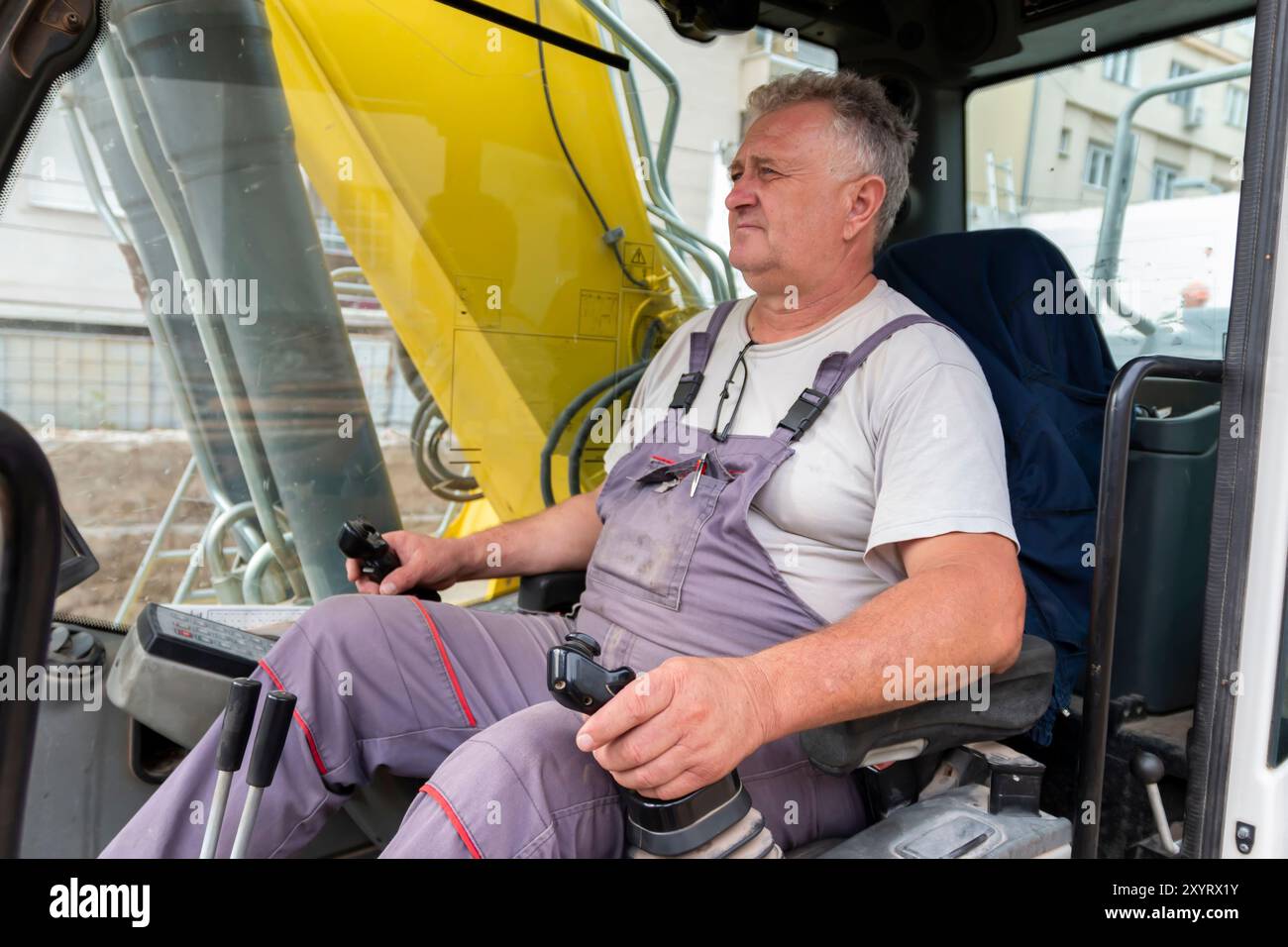 Mature man worker operating excavator on construction site Stock Photo ...
