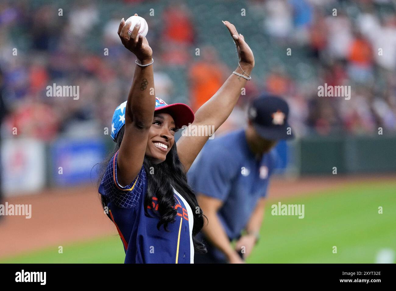 Olympic gymnast Simone Biles waves to the crowd before throwing out the ...
