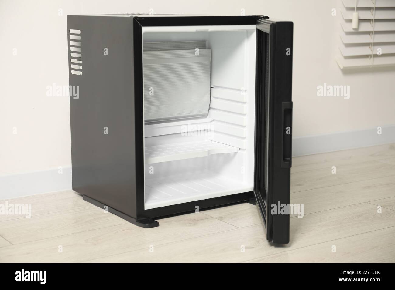 Empty modern mini refrigerator near white wall Stock Photo - Alamy