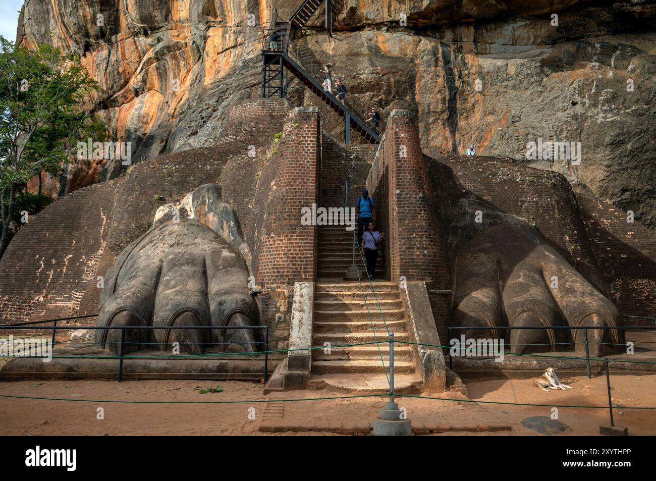 Tourists walk between the Lions Paws on the Lion Platform at Sigiriya ...
