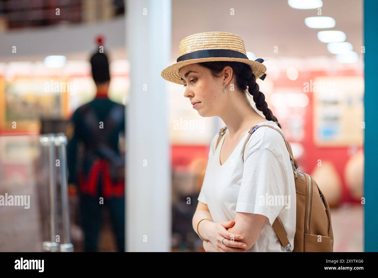 Historic education. Side view of young pensive Caucasian woman student wearing straw hat ...