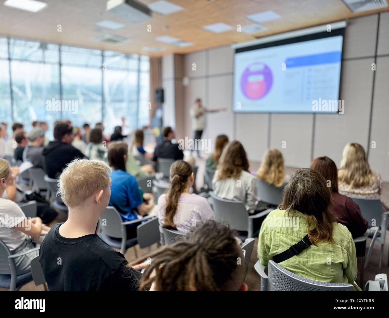 Large group attending business seminar in bright conference room ...
