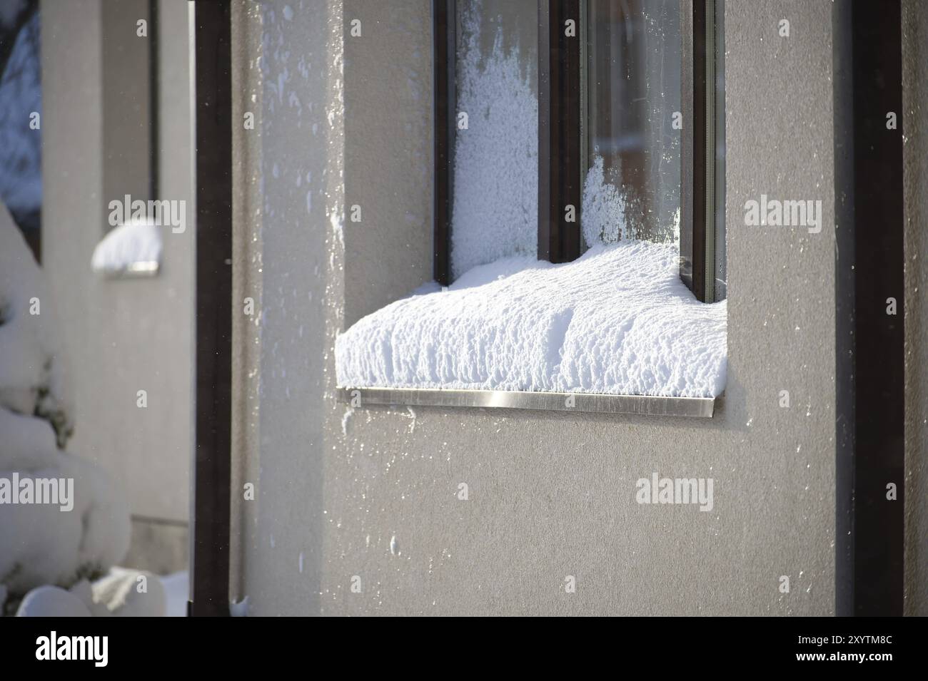 The window, encased in a brown frame, is almost obscured by a thick ...