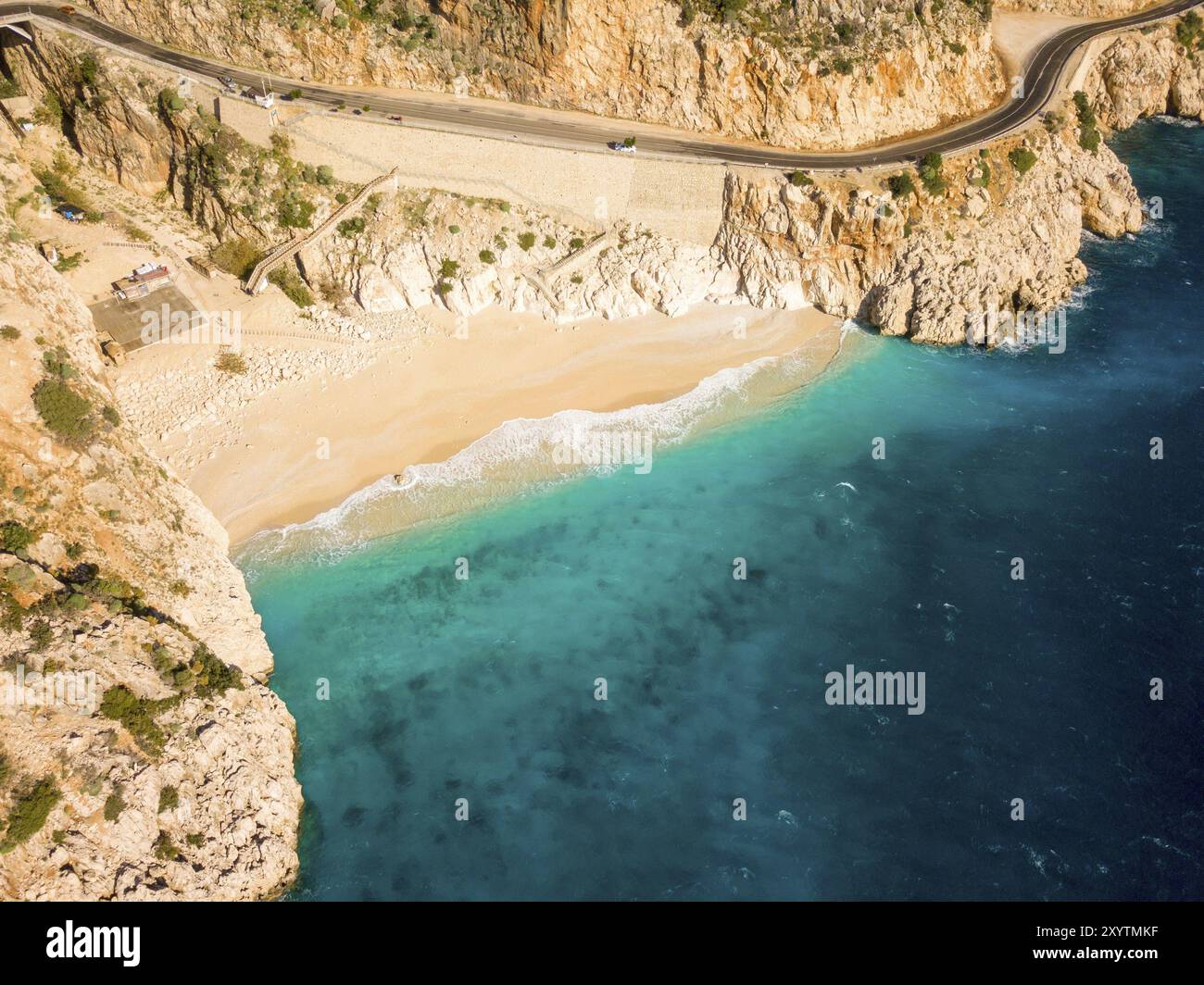 Angled aerial drone view from ocean to sand beach and highway at ...