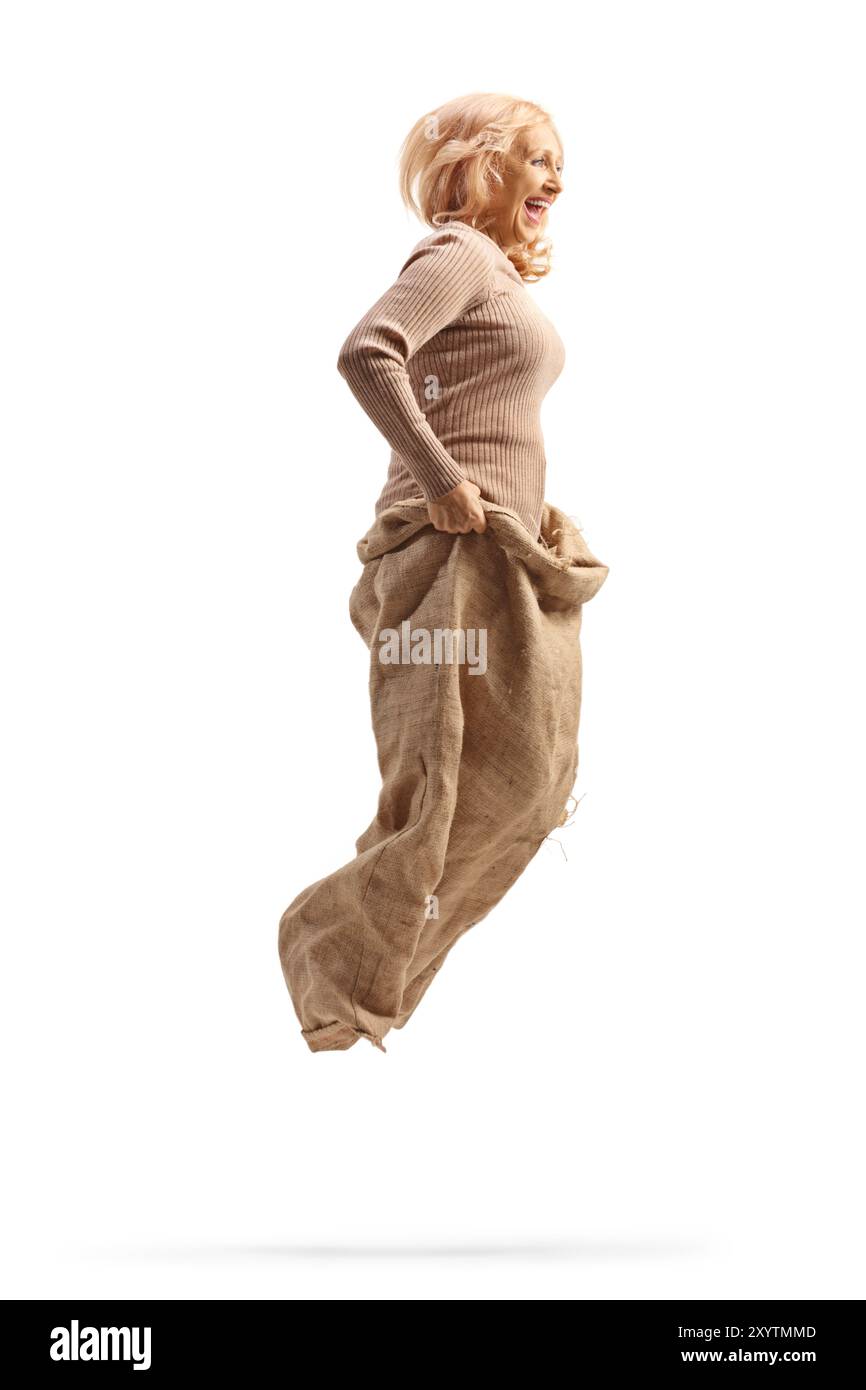 Full length profile shot of a middle aged woman jumping in a sack and ...