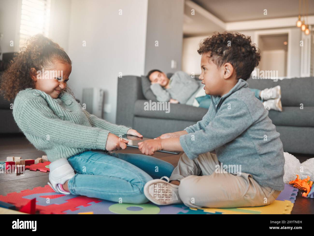 Brother, sister and tablet with fighting in living room of home for ...