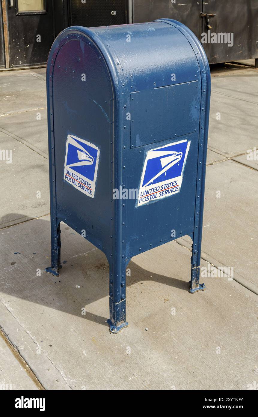 Blue United States Postal Service Mailbox standing on a sidewalk in ...