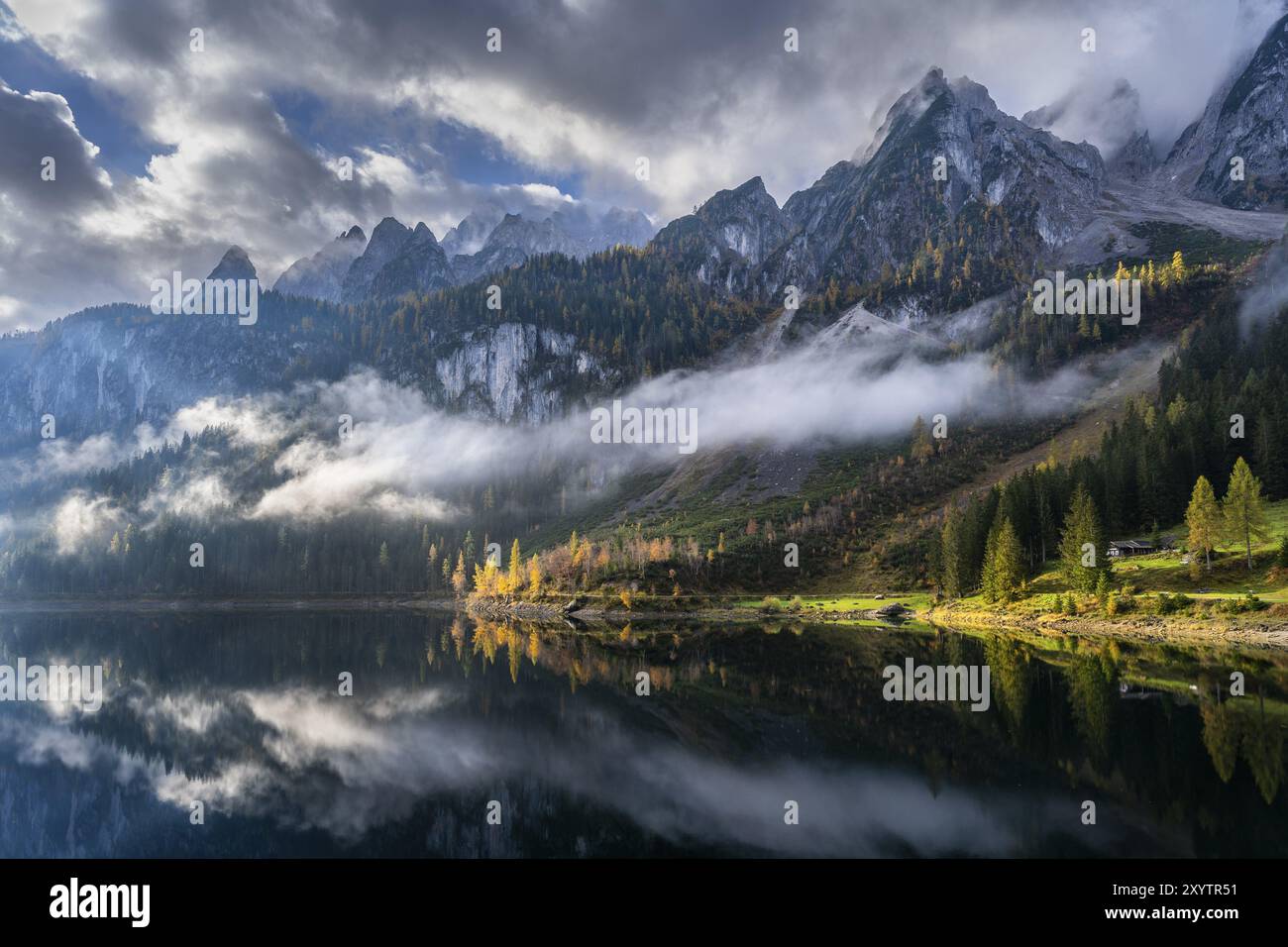 The Vordere Gosausee in autumn with a view of the Gosaukamm. Cloudy sky ...