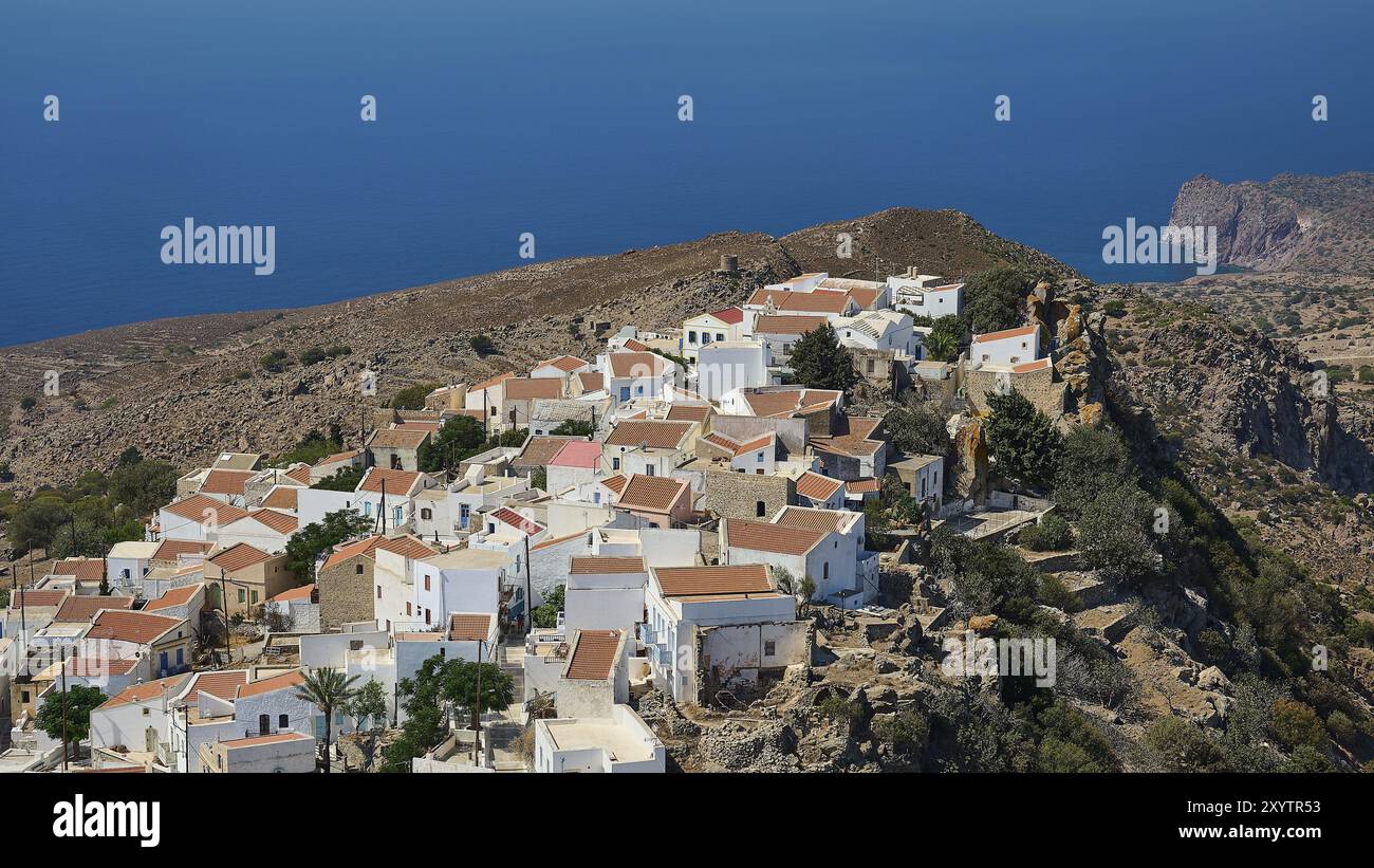 A charming seaside village with white houses on a hill stretching down ...