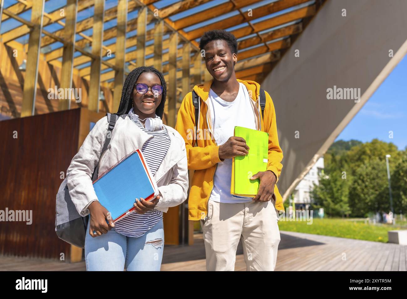 Two male and female young confident african american students walking ...