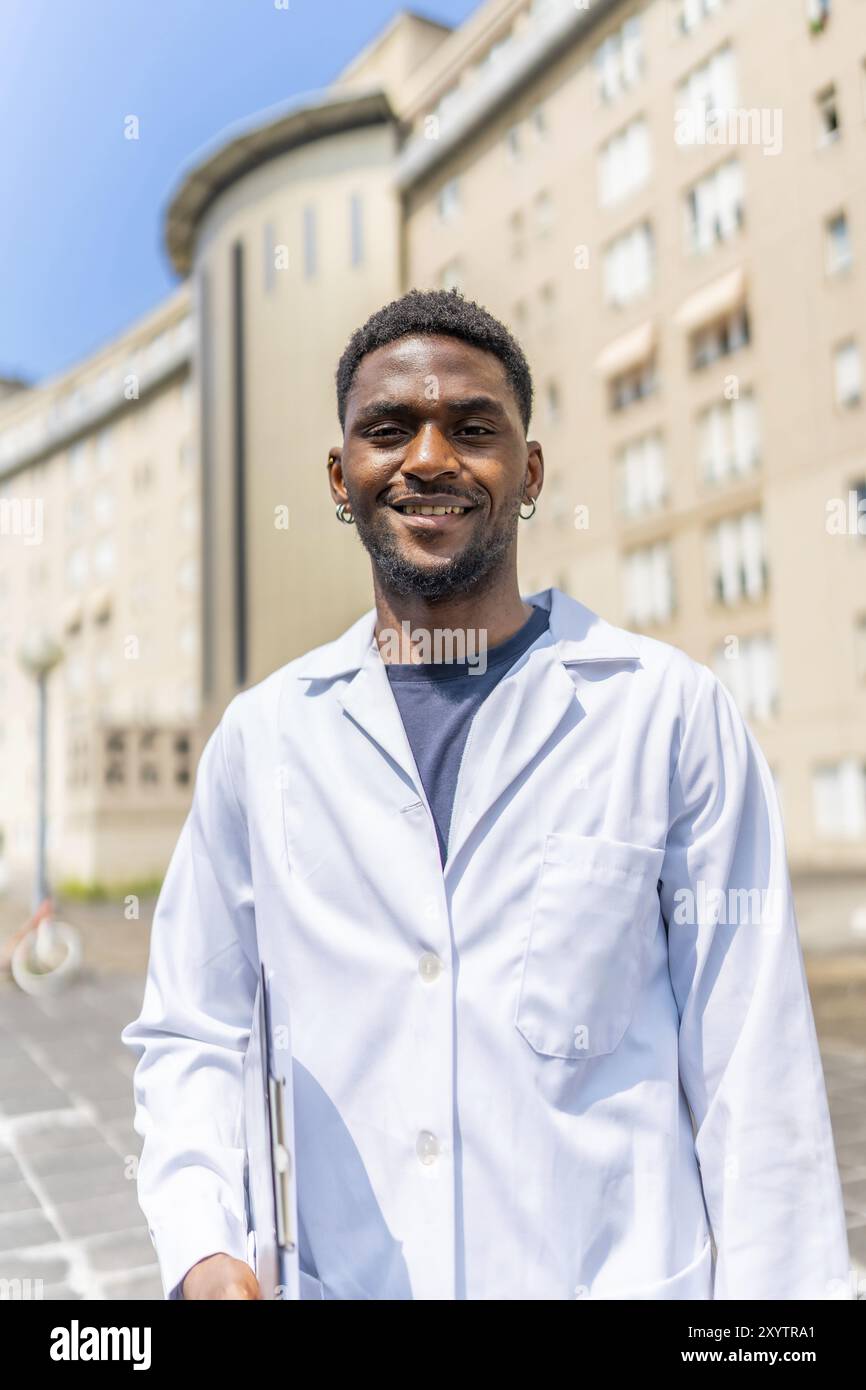 Vertical portrait of a cheerful african doctor smiling at camera ...