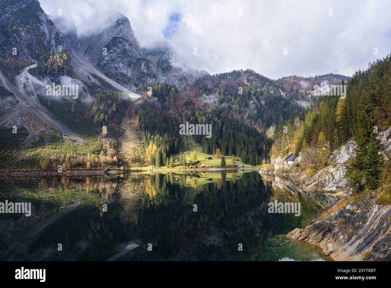 The Vordere Gosausee in autumn. The Gosaukamm on the left. Clouds and ...