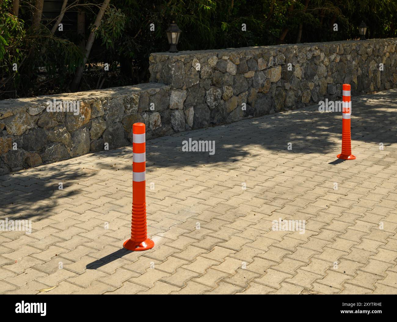 Sidewalk anti-parking bollards with reflective tape in the parking lot ...
