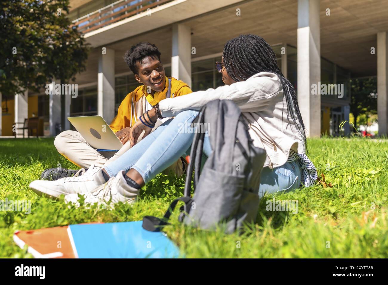 Side view of two male and female african students using laptop studying ...
