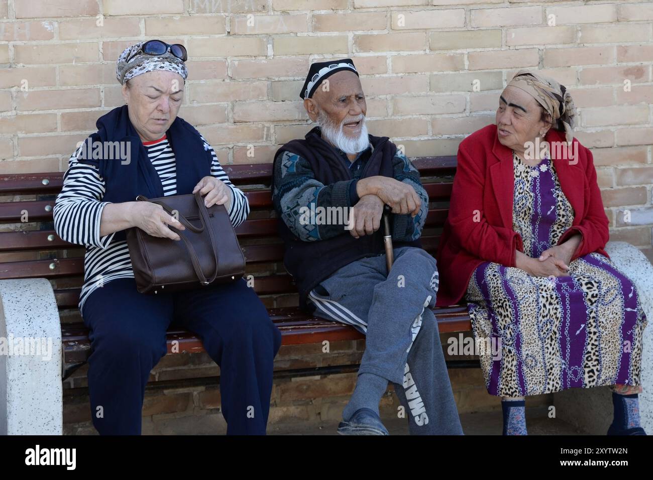 Three elderly people taking a moment of rest on a bench in Bukhara ...