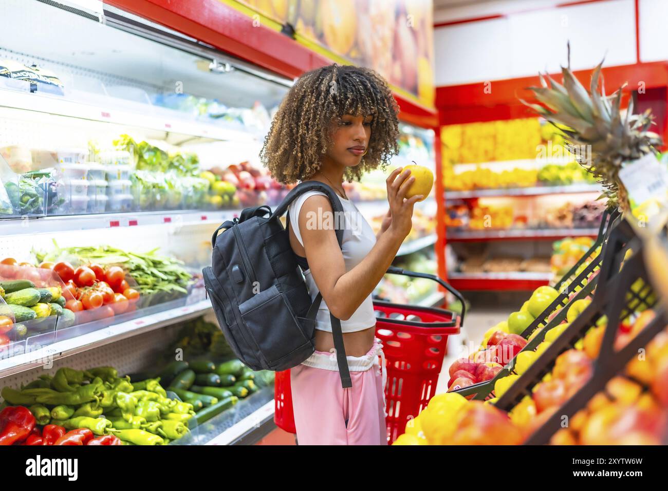 Latin young and casual woman shopping fresh fruit in the supermarket ...