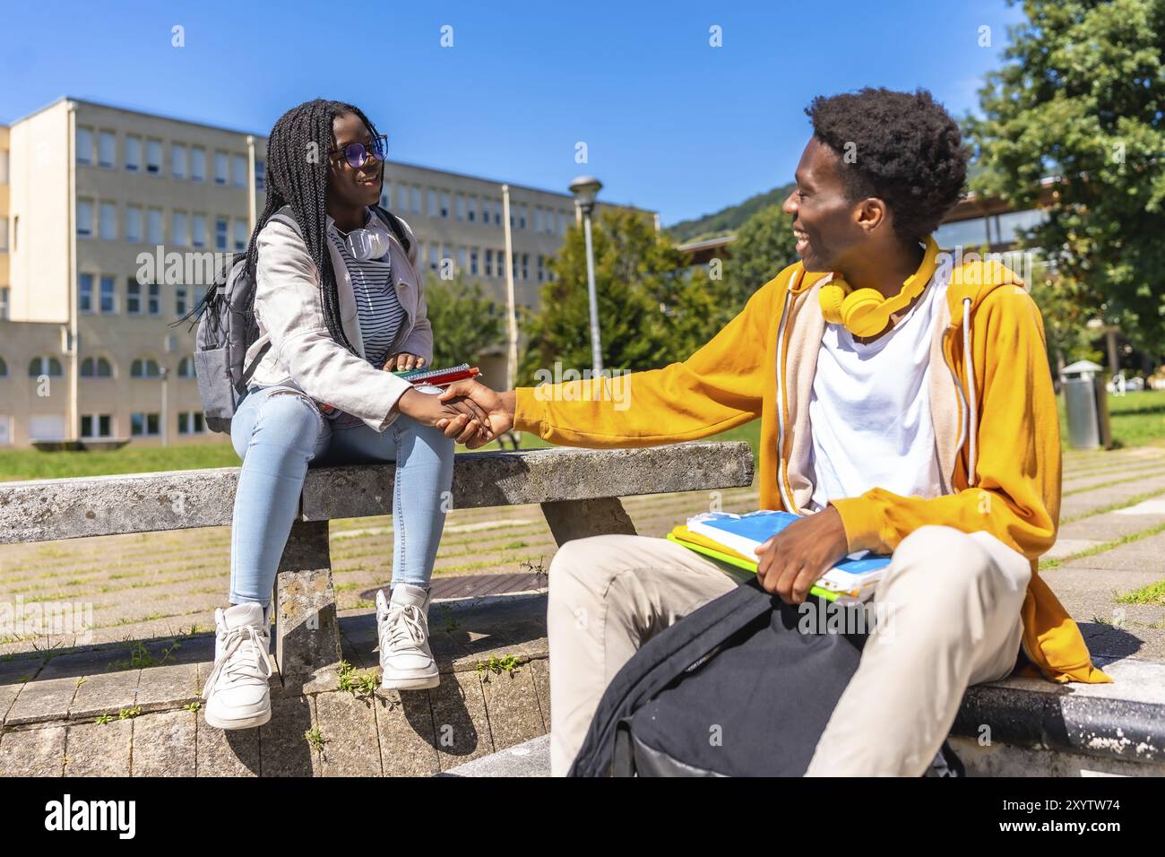 African american students shaking hands sitting on staircases on the ...