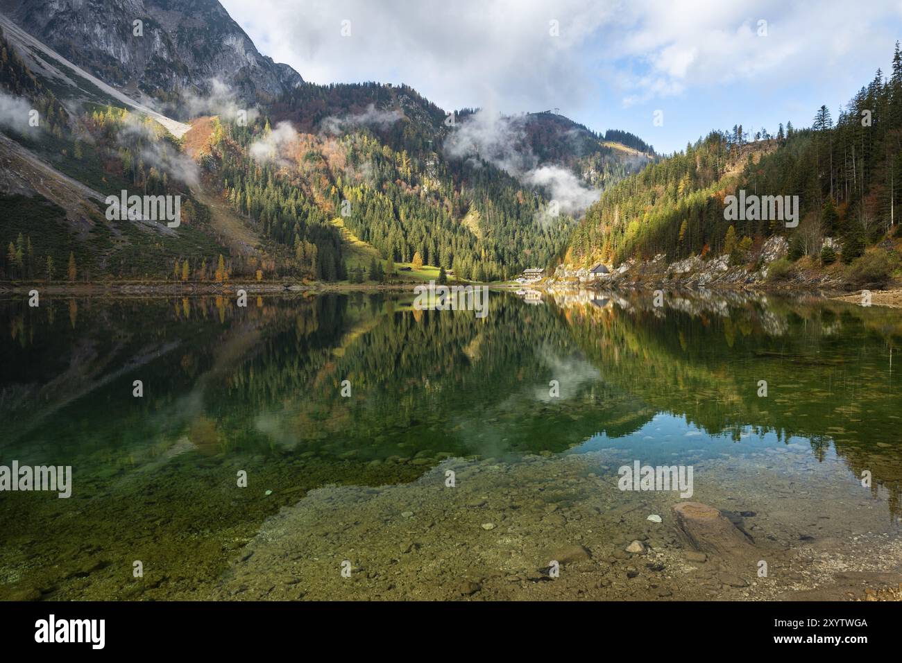 The Vordere Gosausee in autumn with a view of the Gasthof Gosausee. Sun ...