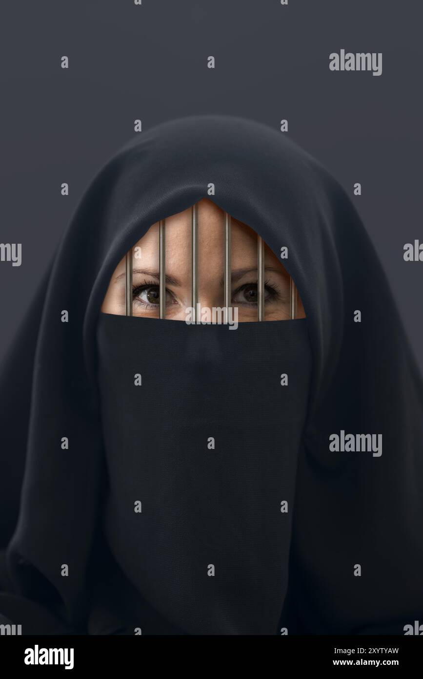 Muslim woman behind bars, symbolic image Stock Photo - Alamy