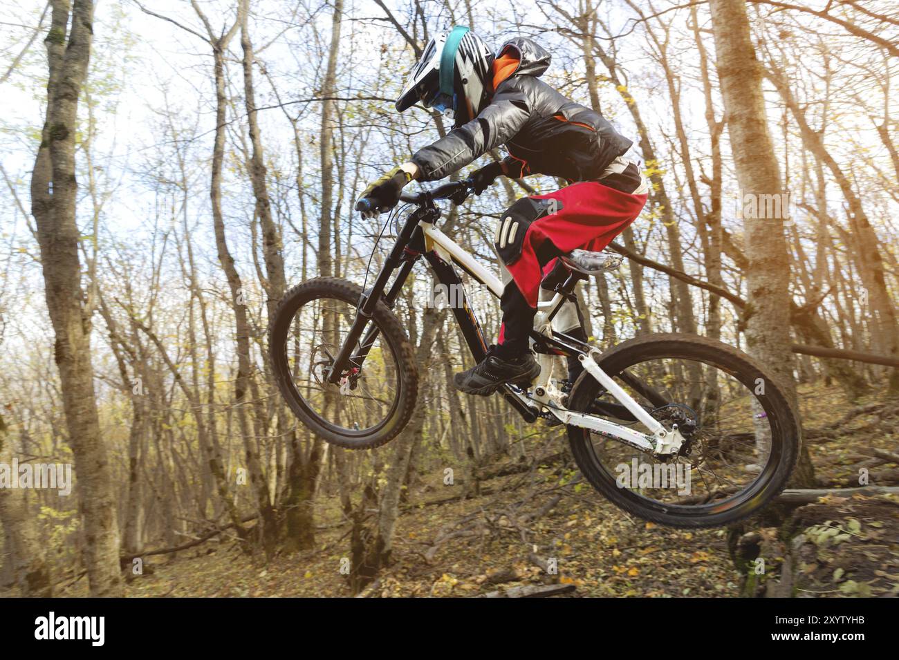 A young rider at the wheel of his mountain bike makes a trick in ...
