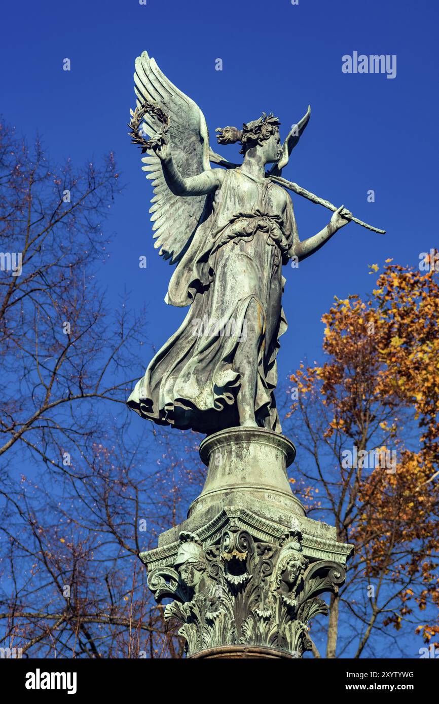 Statue of an angel on a column in bright sunshine in autumn with clear ...