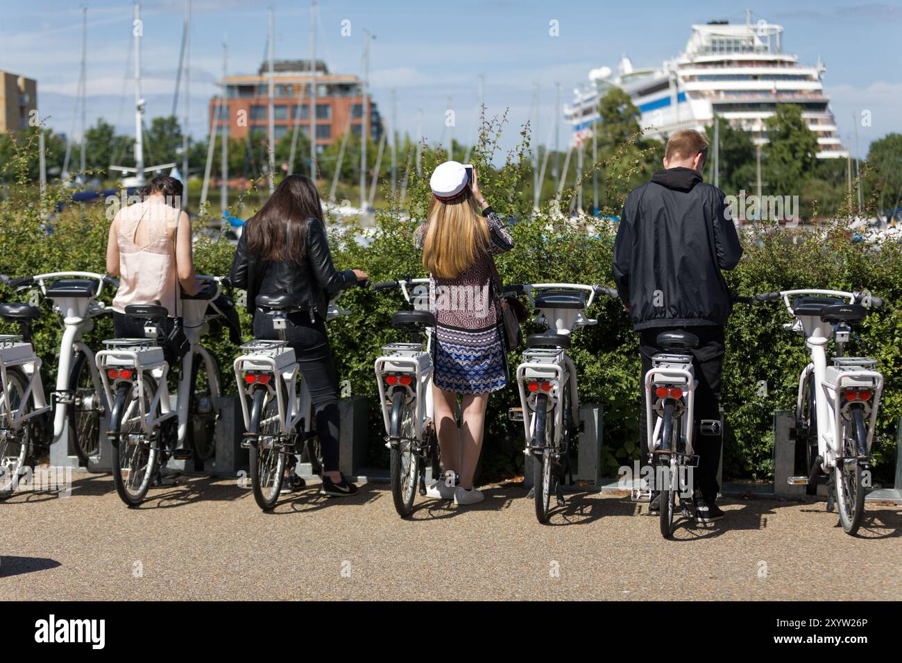 Four young people rent an e-bike Stock Photo - Alamy