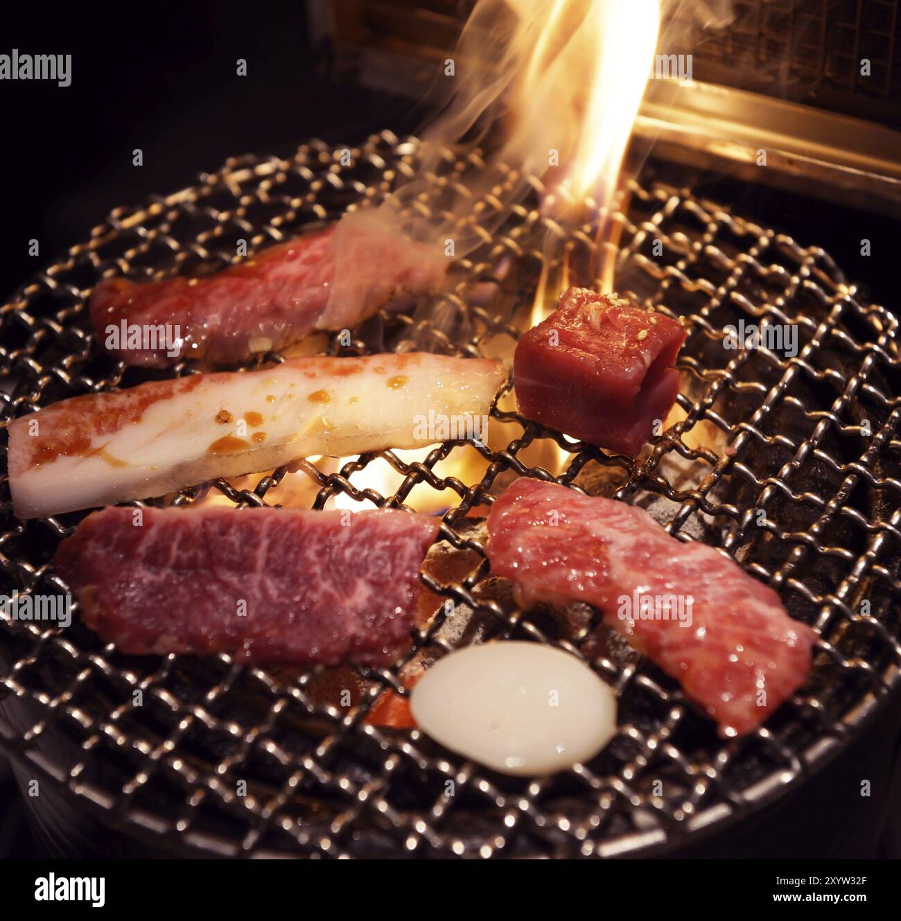 Meat on grill being cooked on fire at a Japanese grill restaurant ...