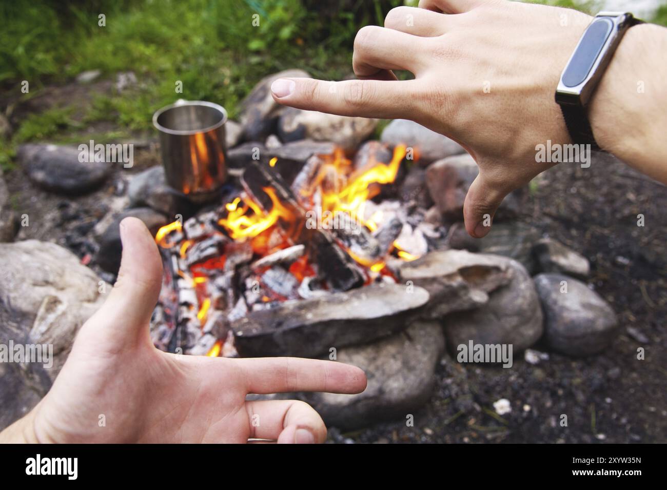 Men's hands are warming around the campfire in the forest Stock Photo ...