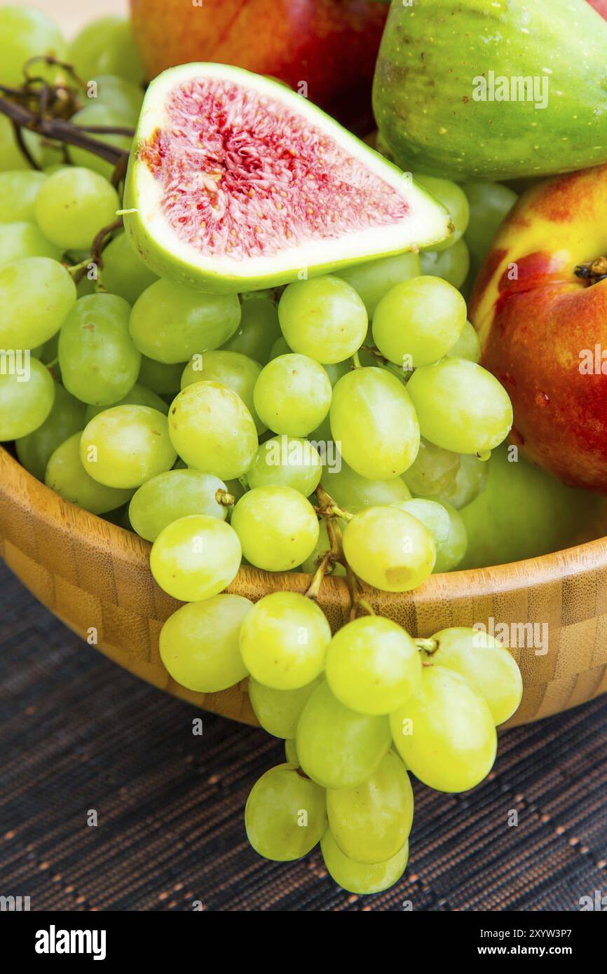 Bowl with fresh organic fruits green grapes, peach, cutted fig Stock ...