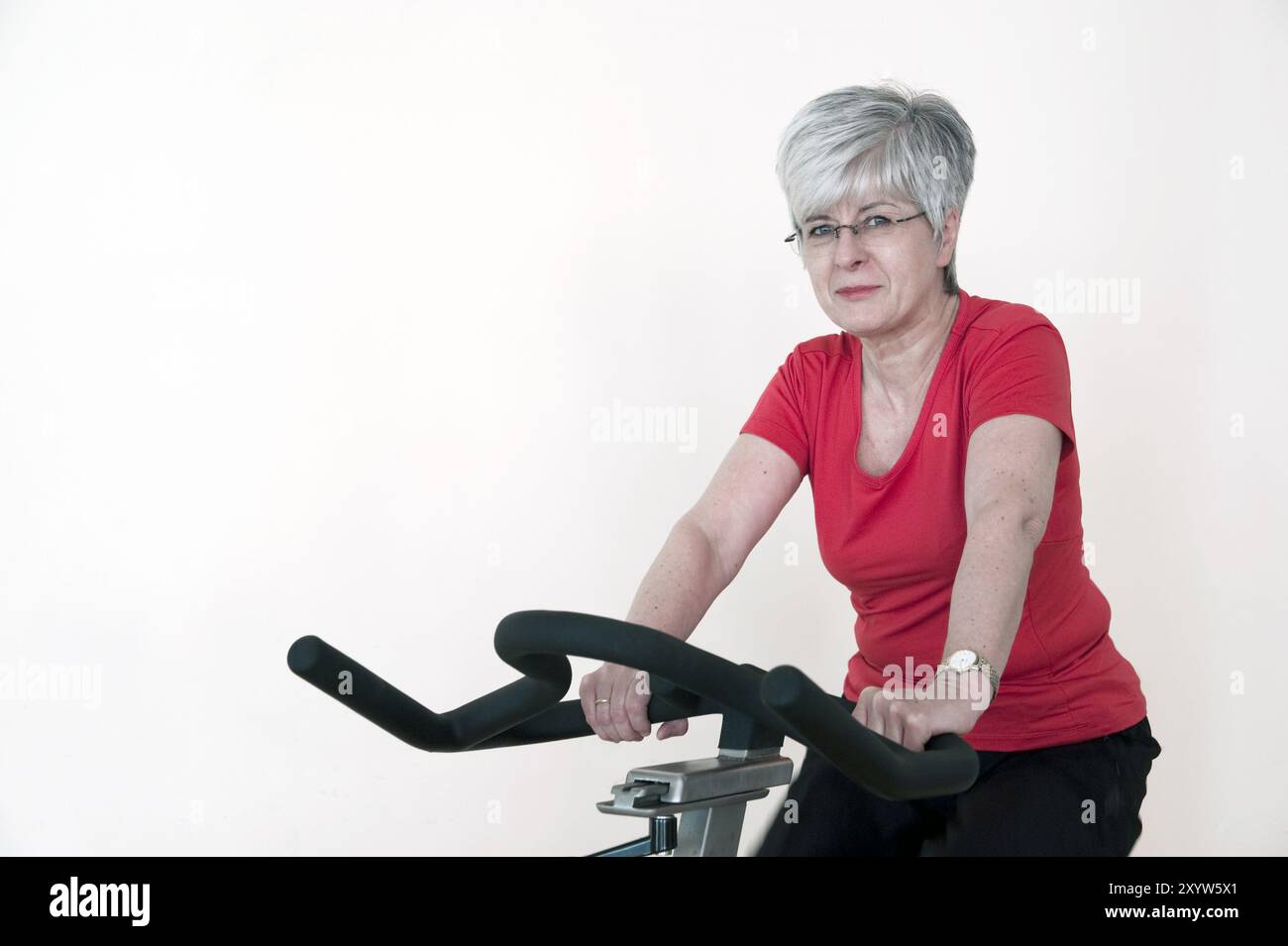 Woman, 50+, training on a cycle ergometer Stock Photo - Alamy