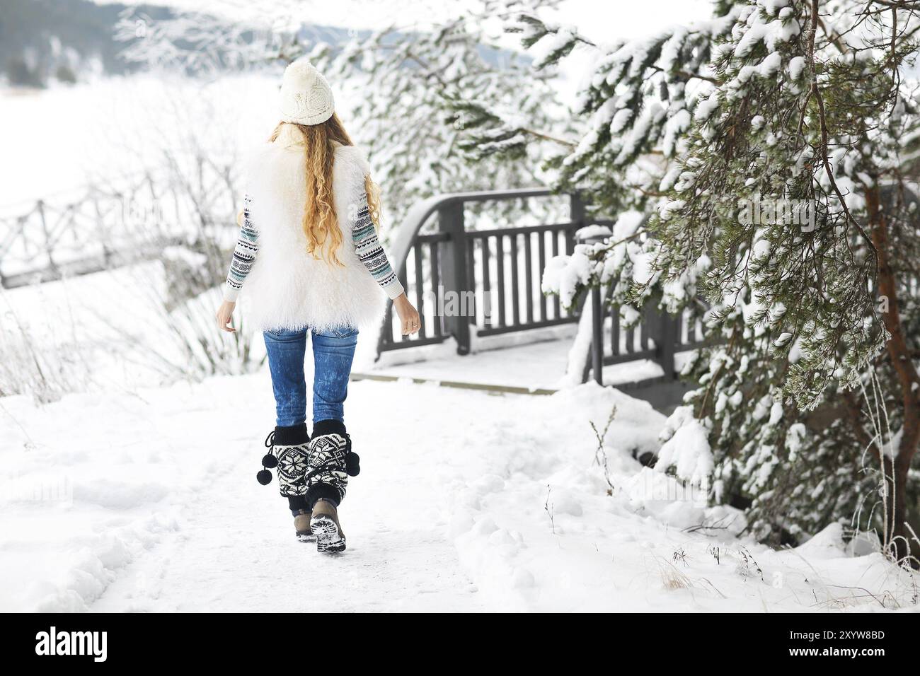 Young woman walking at park covered with snow. Back view Stock Photo ...