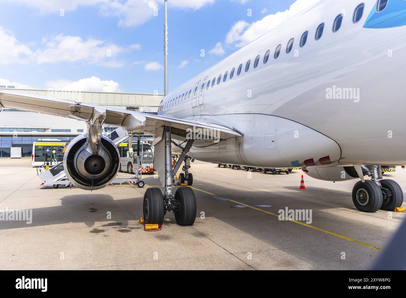 A large white airplane with a blue stripe on the tail. The plane is ...