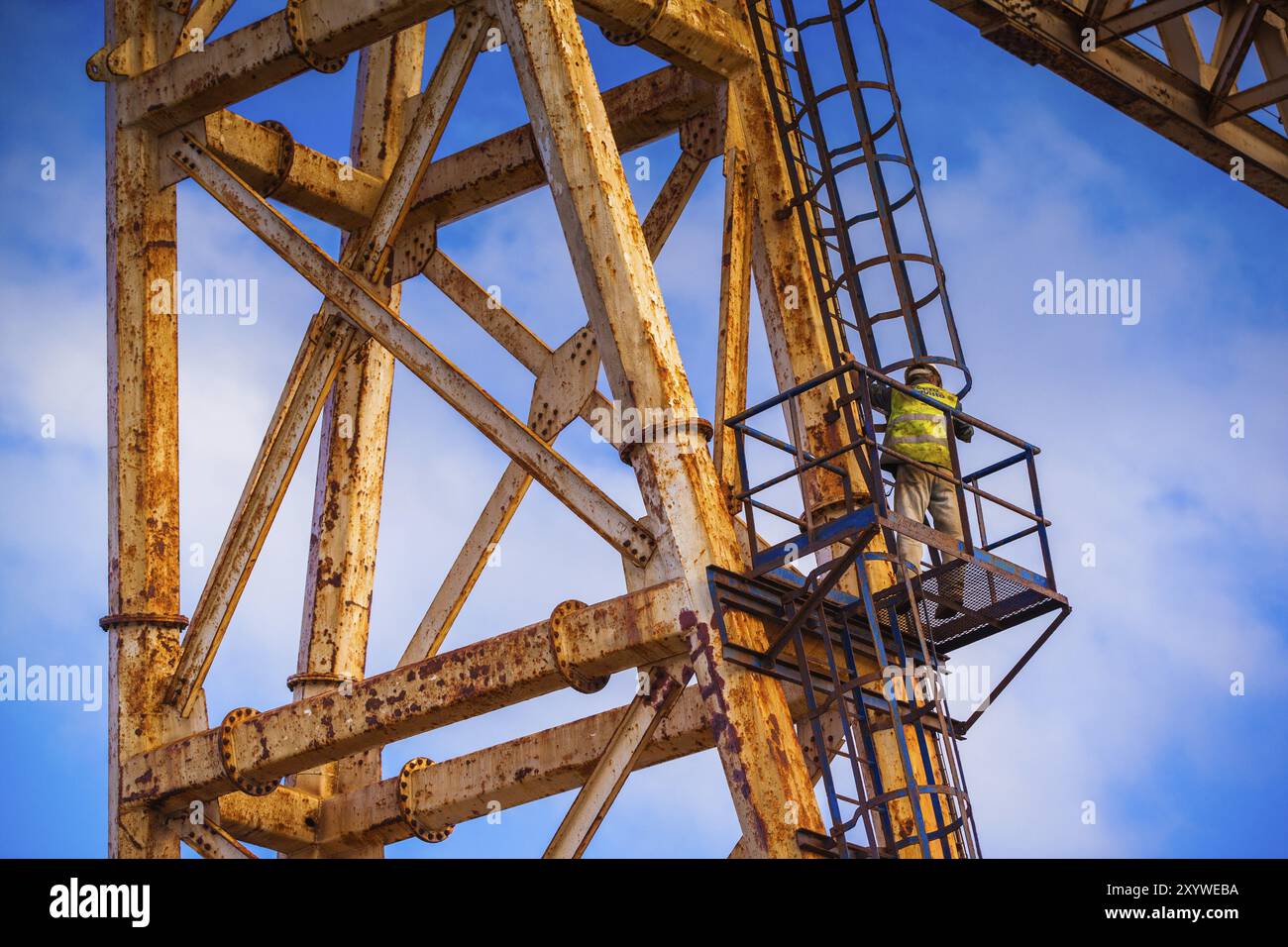 Worker climbing on a crane Stock Photo - Alamy