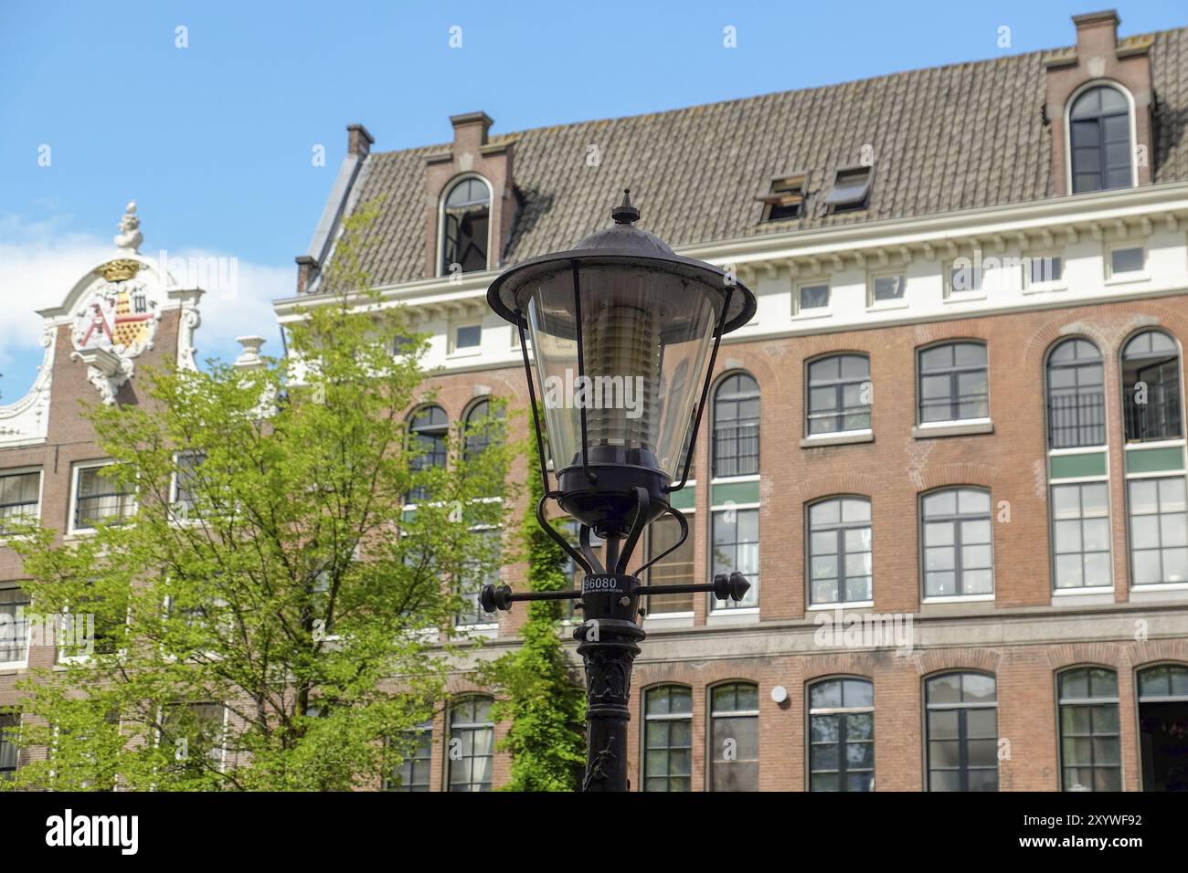 An old-fashioned street lamp in front of a historic building with many ...