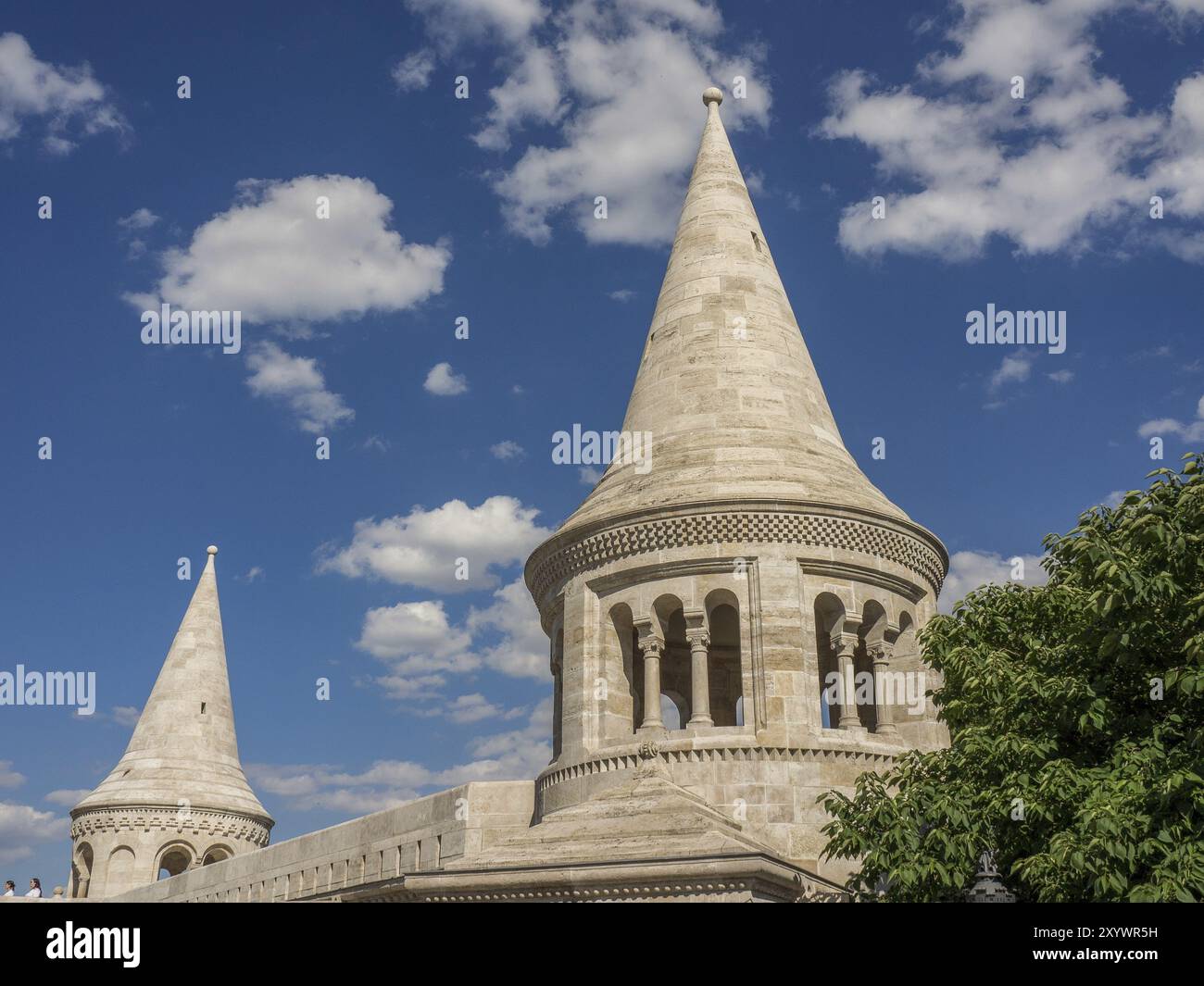 Two historic stone towers with blue sky and clouds in the background ...
