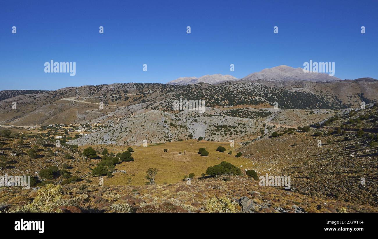 Vast landscape with mountains and sparse vegetation under a bright blue ...